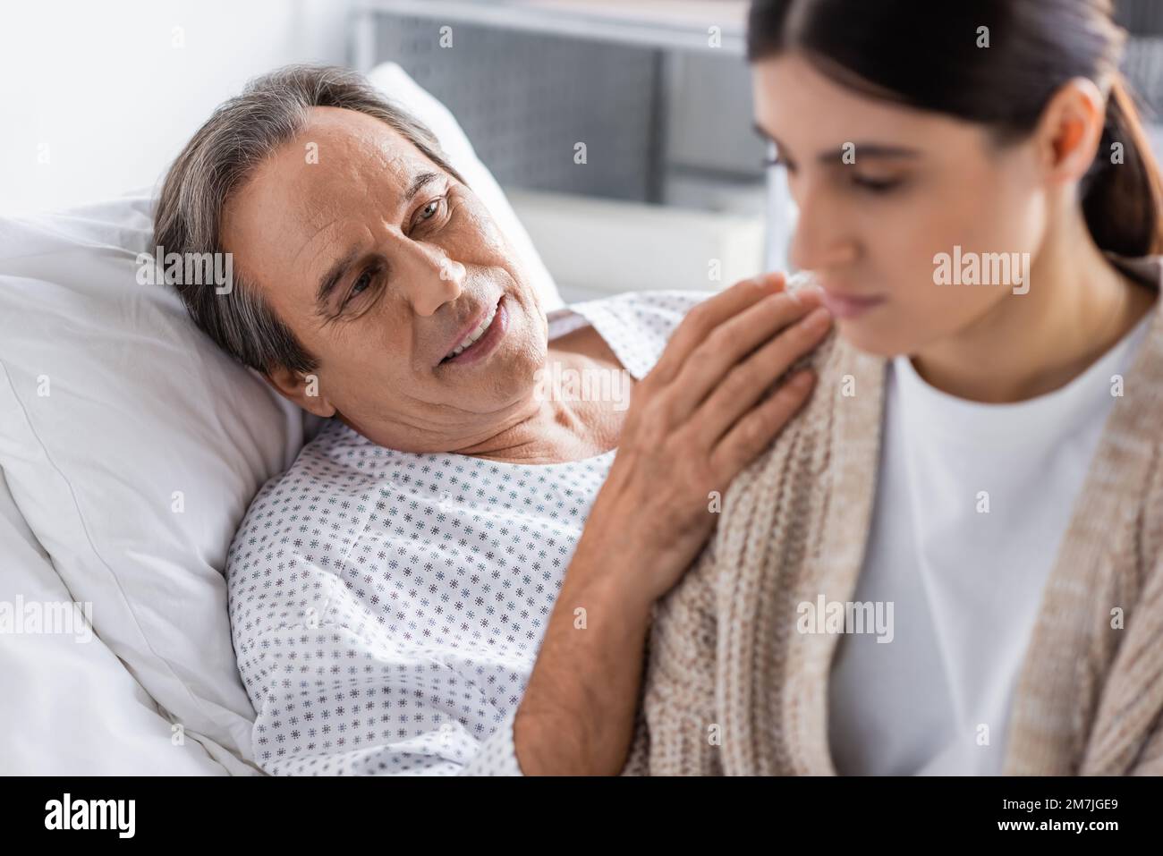 Smiling senior patient calming blurred daughter in clinic,stock image ...