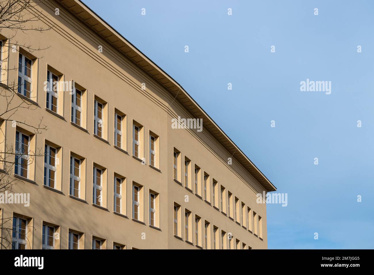 Corner of a building against blue sky. Beige plaster, simple, linear ...