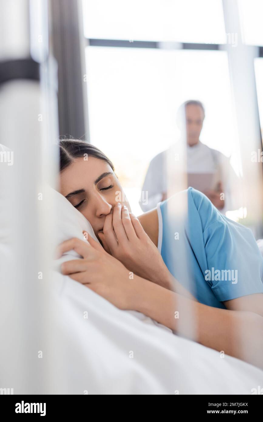 Sad patient lying with closed eyes on bed in hospital ward,stock image ...