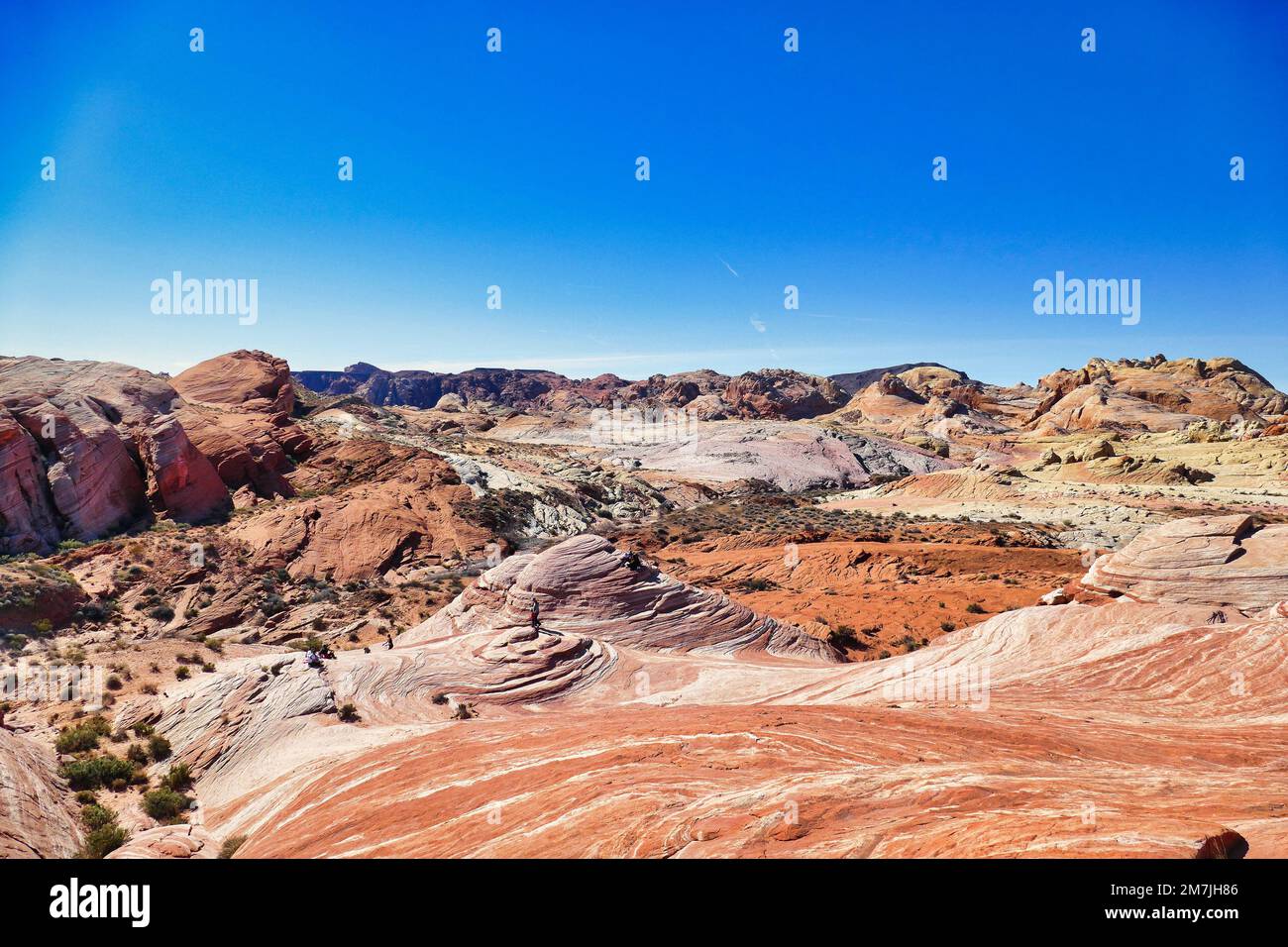Arid landscape with striated red and white rocks along the White Domes ...