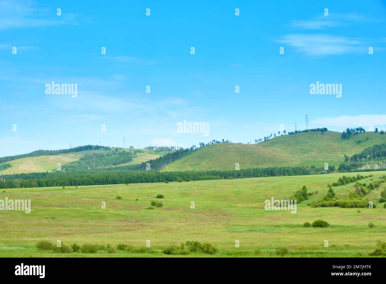Green meadows of the Trans-Baikal Territory in Russia against a blue ...