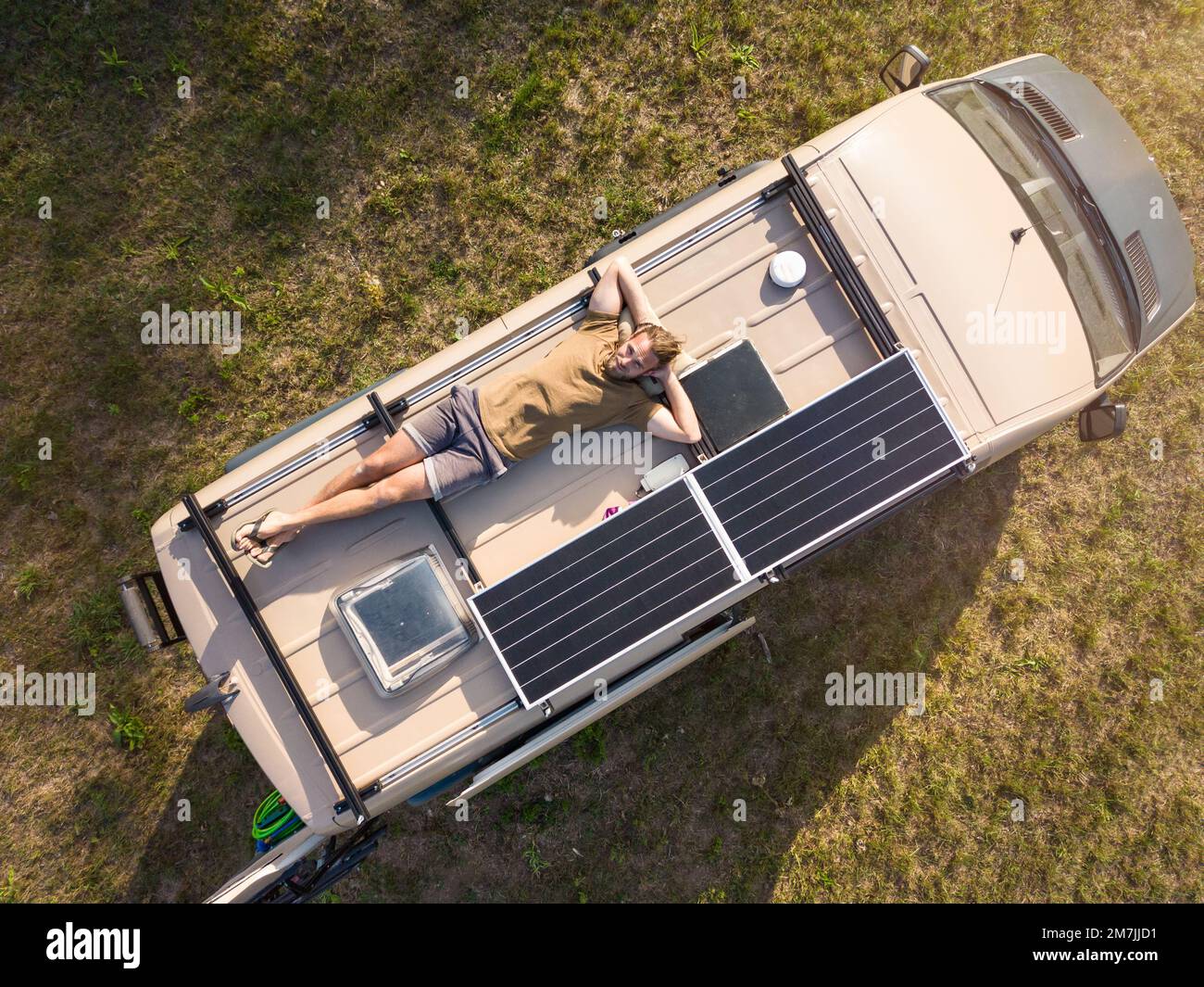 Aerial view of a man lying on the roof of a camper van Stock Photo - Alamy