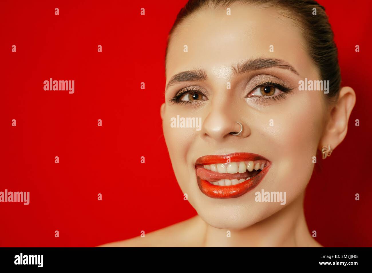 Portrait of a smiling beautiful young woman. Red background. Studio ...