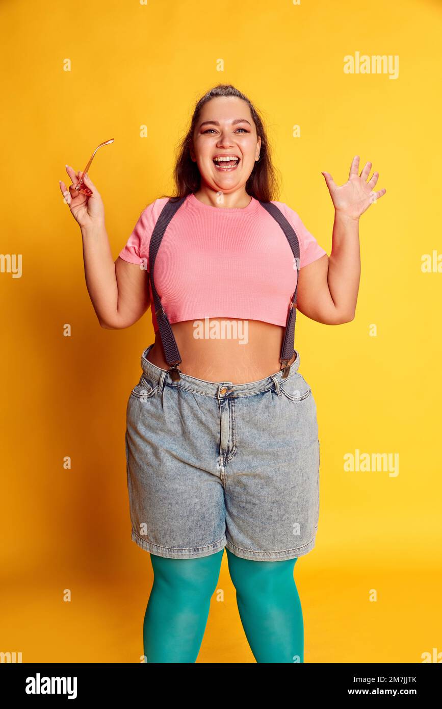 Super happy. Portrait of young overweight woman in casual bright ...