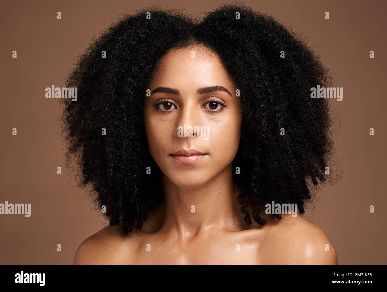 Face, skincare and afro with a model black woman in studio on a brown ...