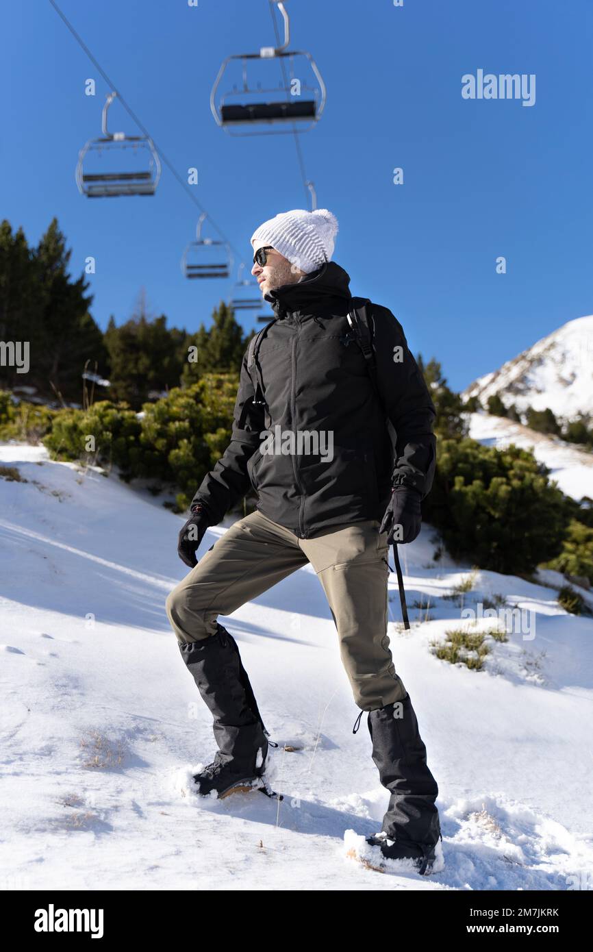 Adult male model hiking in mountains full of snow in a sunny day Stock ...
