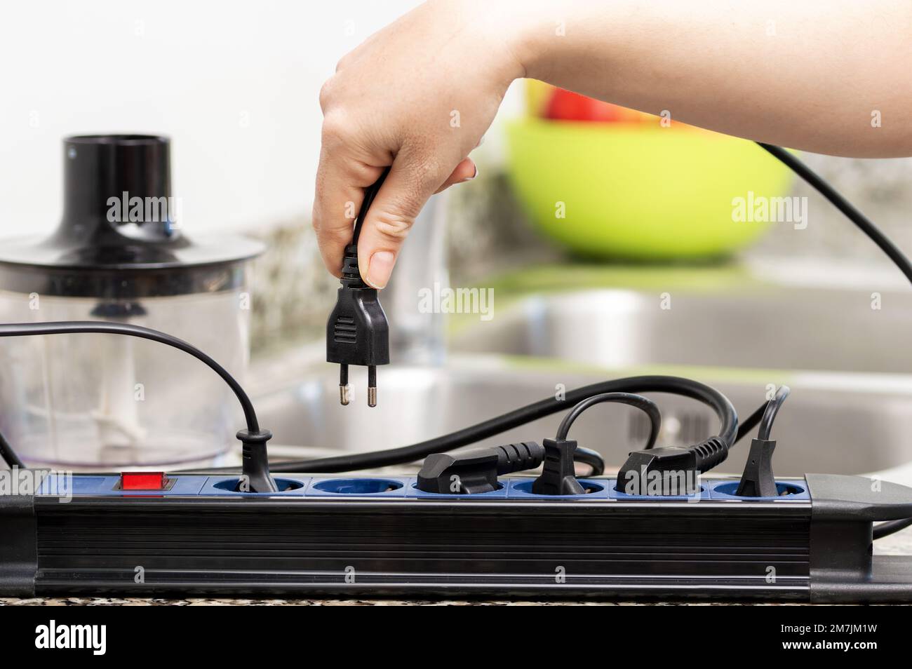 Close up of a woman hand plugging a plug in an electrical socket on a ...