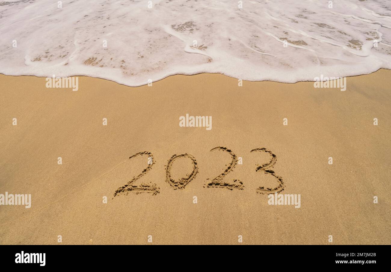 2023 hand written in sand on a beautiful beach Stock Photo - Alamy