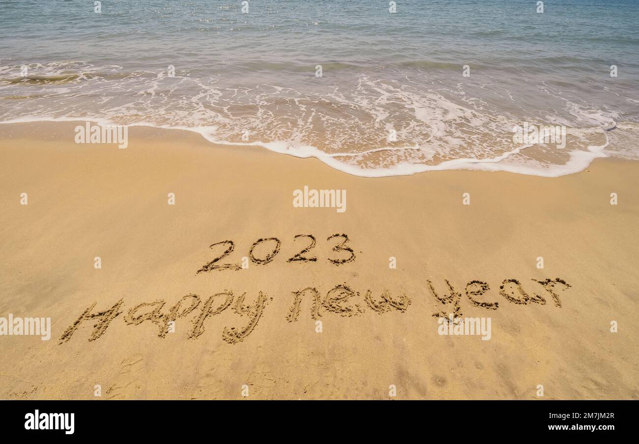 2023 happy new year handwritten in sand on a beautiful beach Stock ...