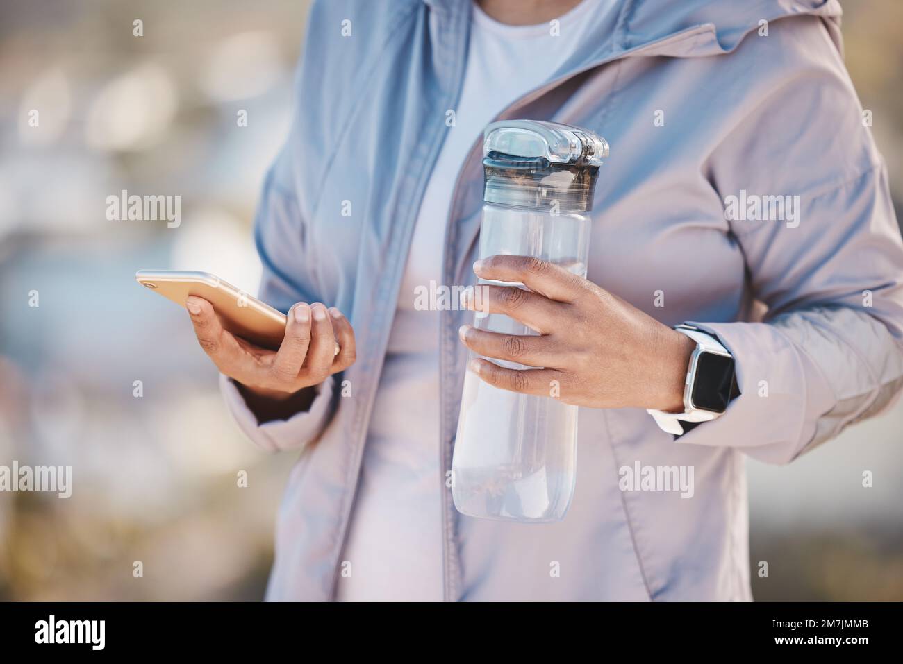 Running, water and phone with hands of woman in mountain for jogging, workout or cardio training ...