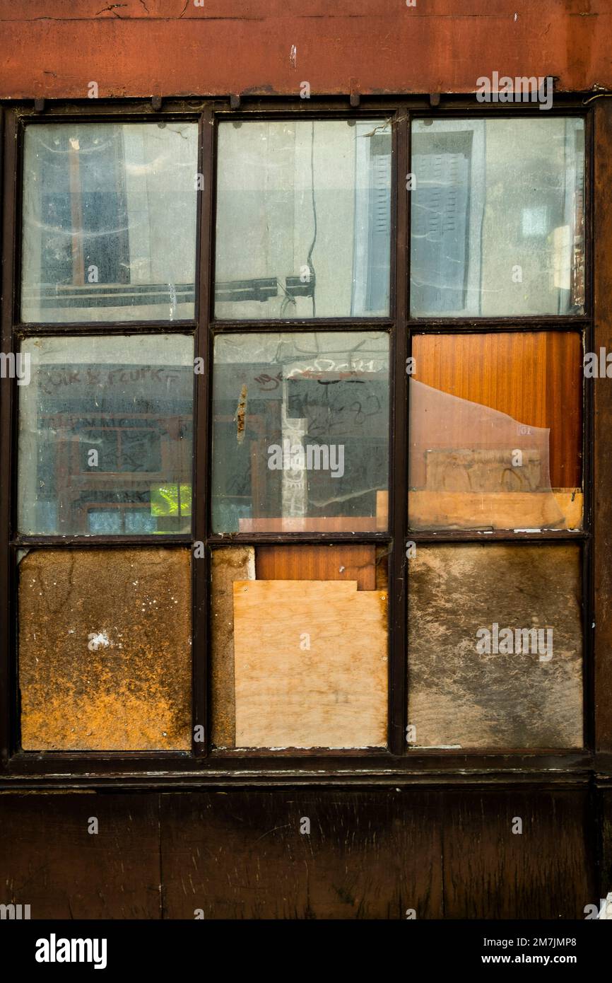Close-up of an old, weathered window with peeling paint and fogged ...