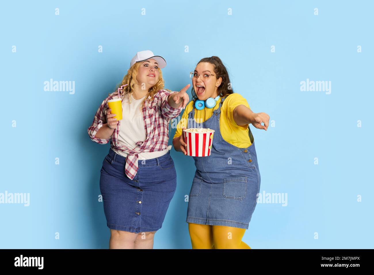 Portrait of two fat, beautiful women, friends posing with popcorn ...