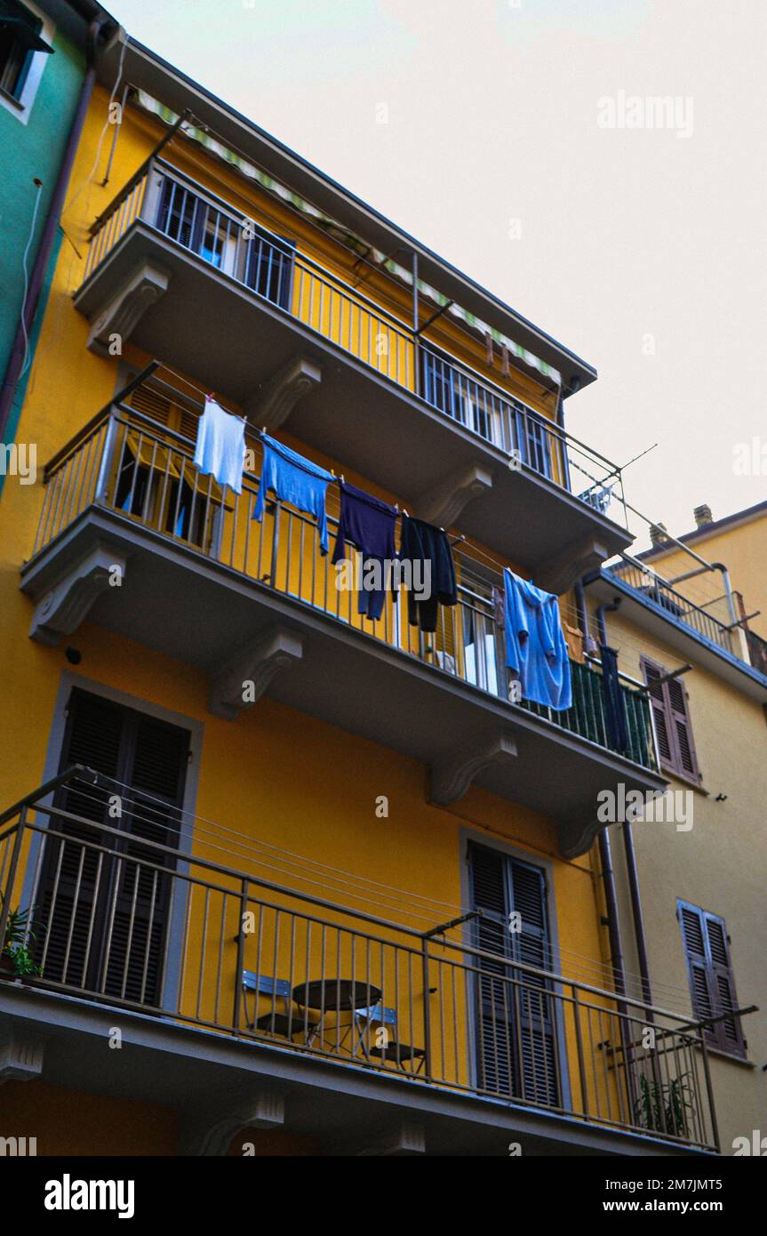 A vertical shot of the yellow building with balconies and clothes ...