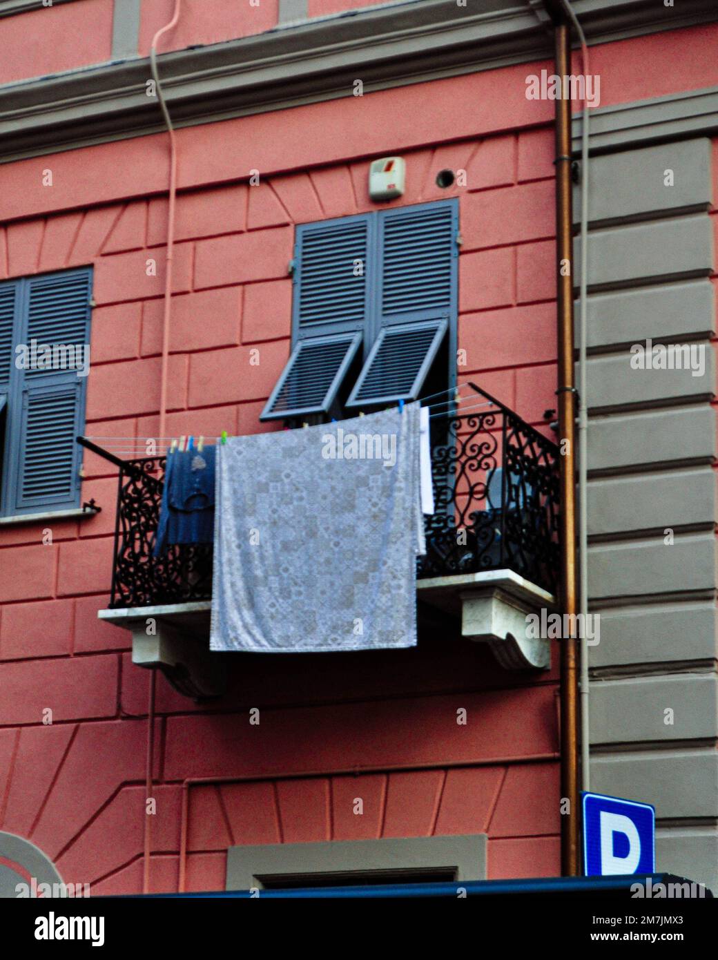 A vertical shot of the red building with balconies and clothes drying ...