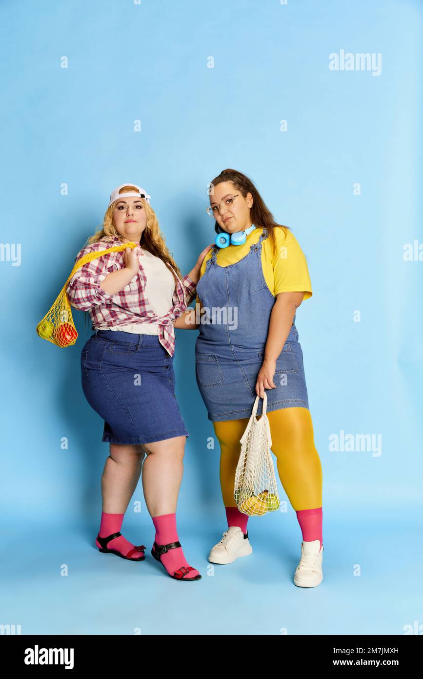 Portrait of two fat, beautiful women, friends posing with bag with ...
