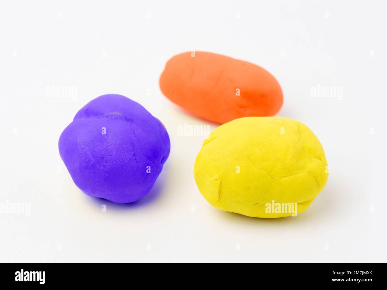 Blue, red and yellow moulds of plasticine in a white surface Stock ...