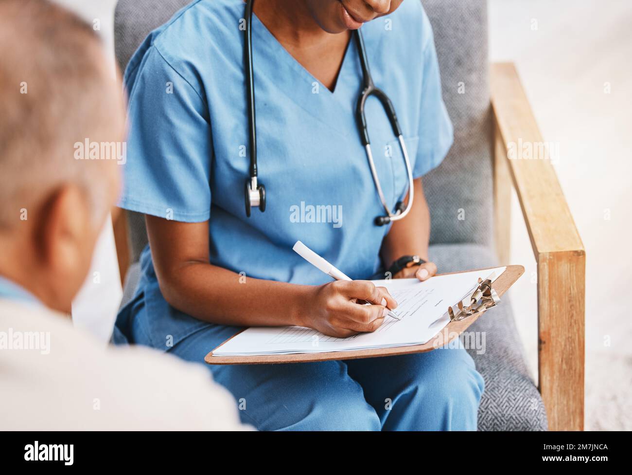 Nurse, writing notes and medical history with patient for healthcare ...