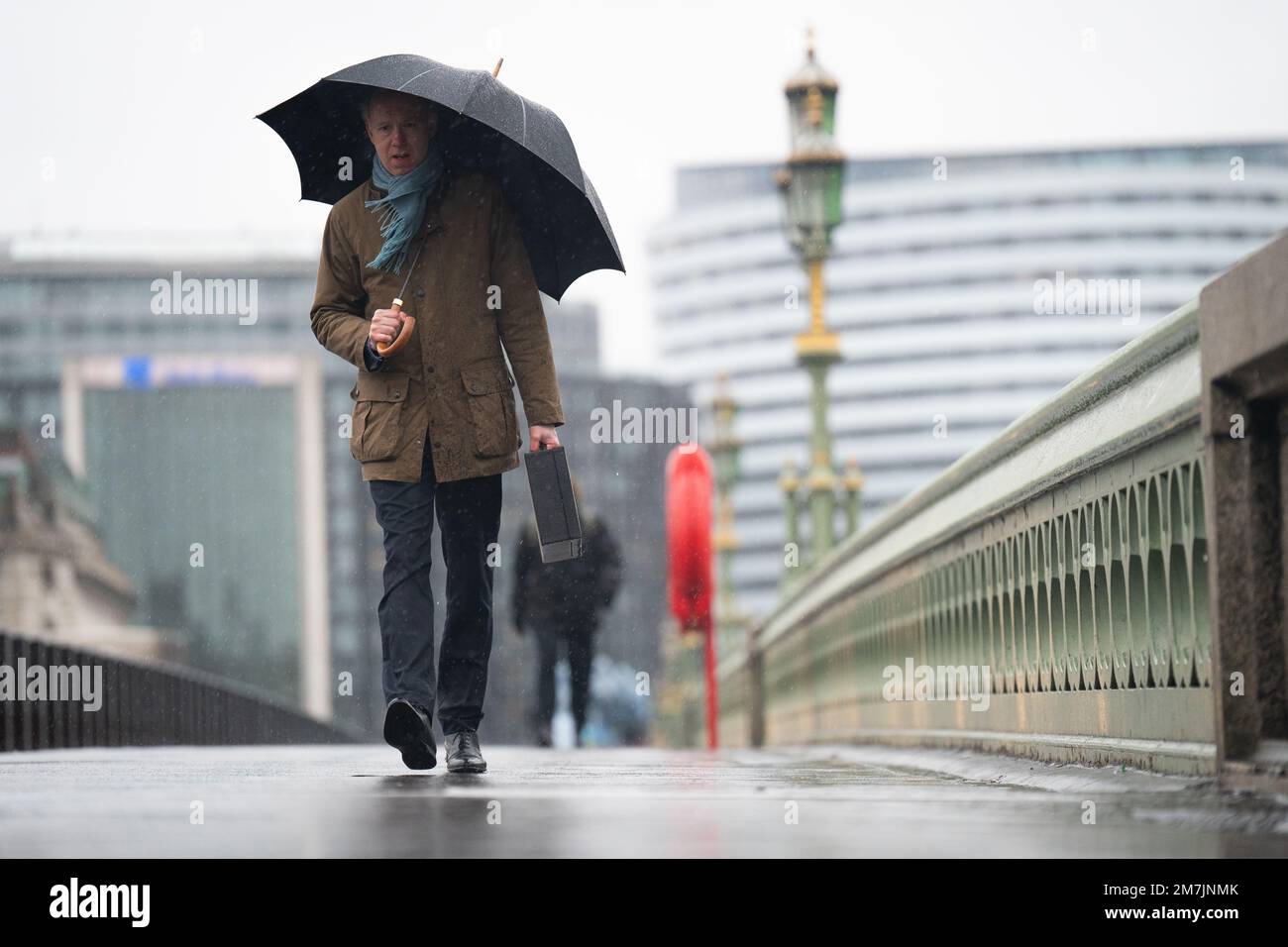 People walk along Westminster Bridge, central London in the rain. The ...