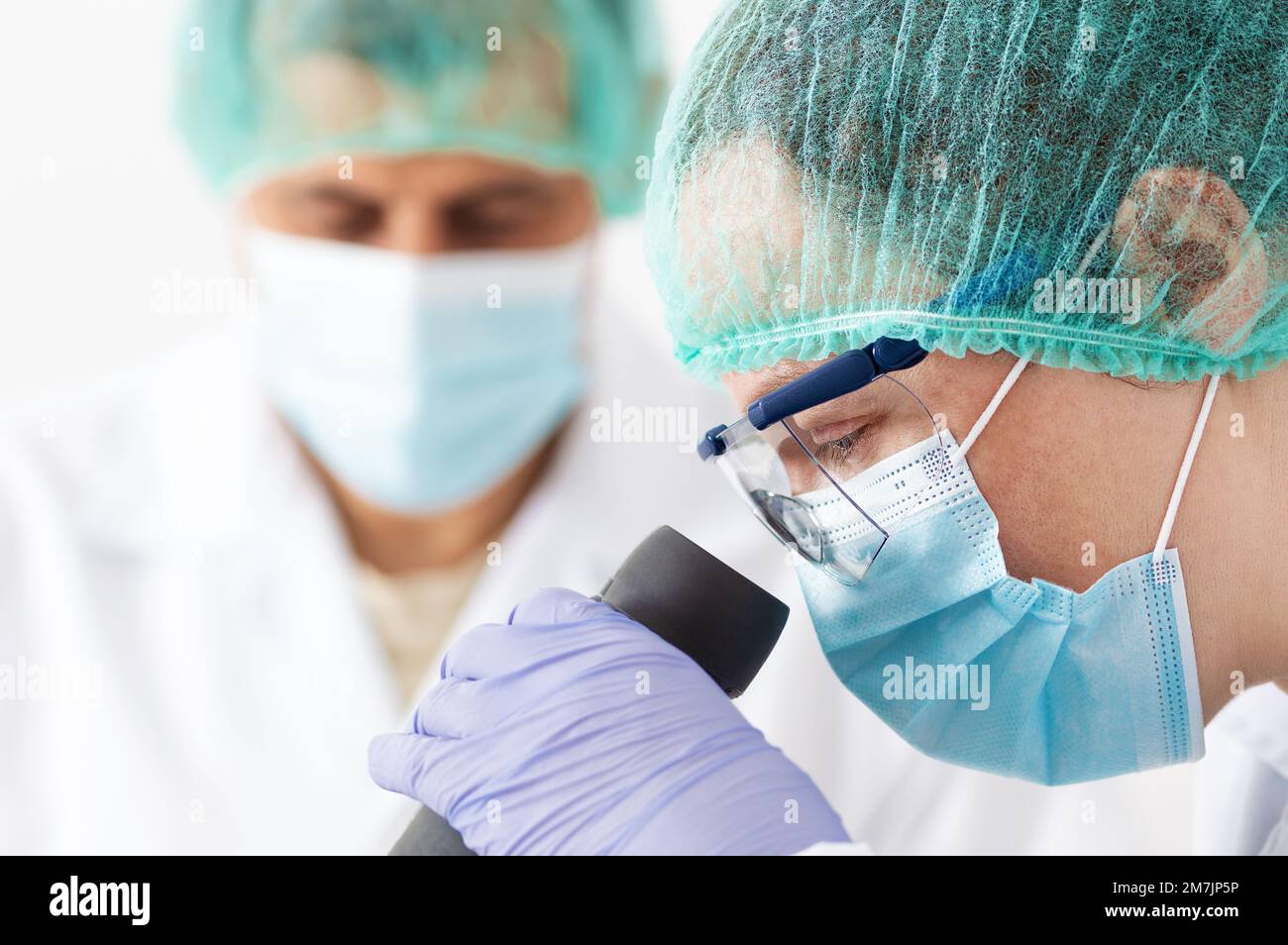 Biochemical research scientist team working with microscope for vaccine ...