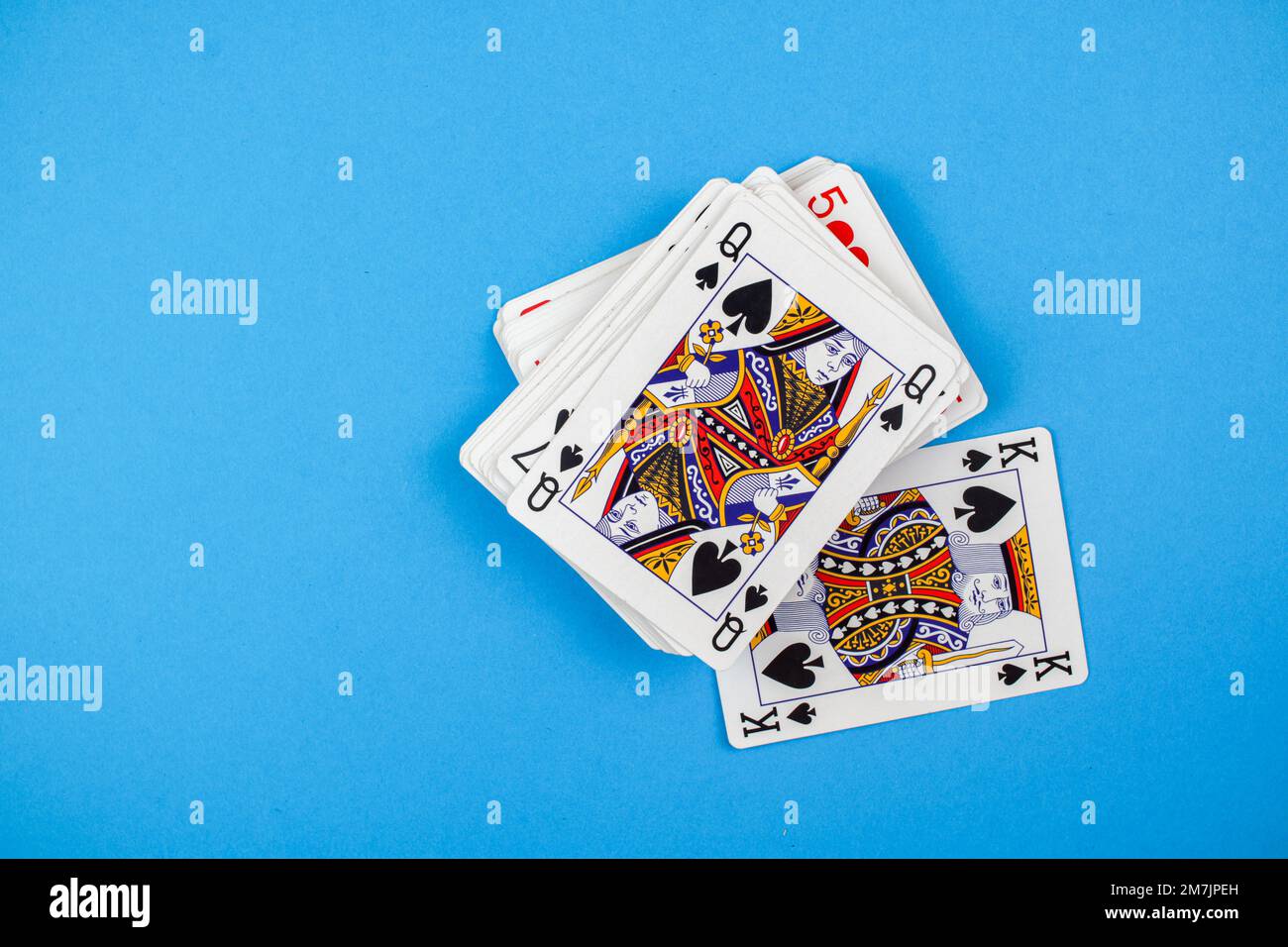 A top view of a pack of playing cards isolated on a blue background ...