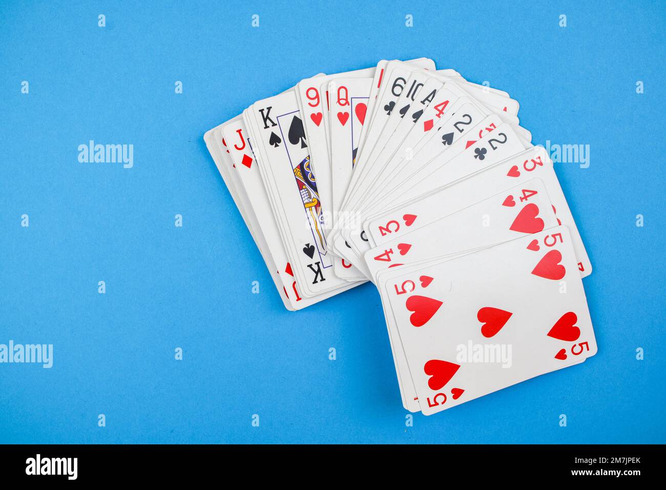 A top view of a pack of playing cards isolated on a blue background ...