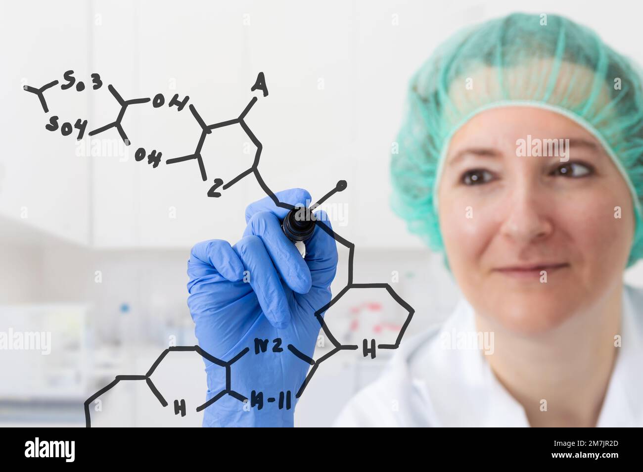Shot of a focused young female scientist solving equations on a glass ...