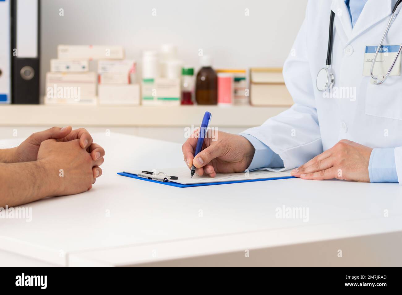Doctor writing in patient chart hi-res stock photography and images - Alamy