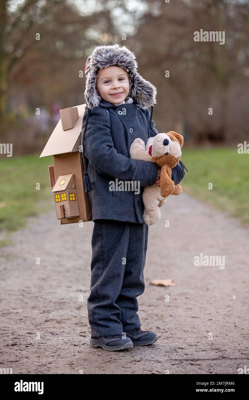 Little child, blond boy with pet dog, carying home on his back, kid ...