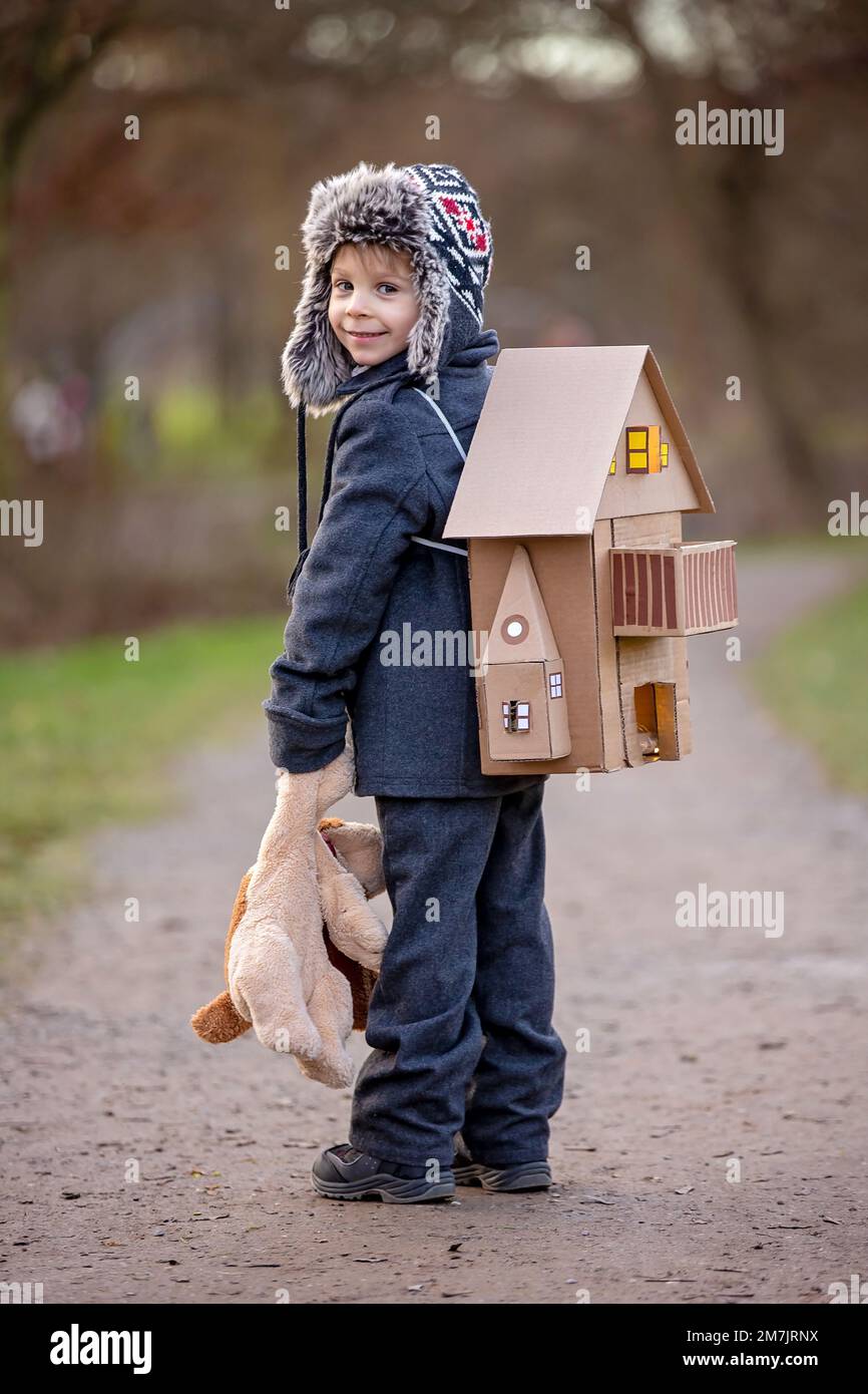 Little child, blond boy with pet dog, carying home on his back, kid ...