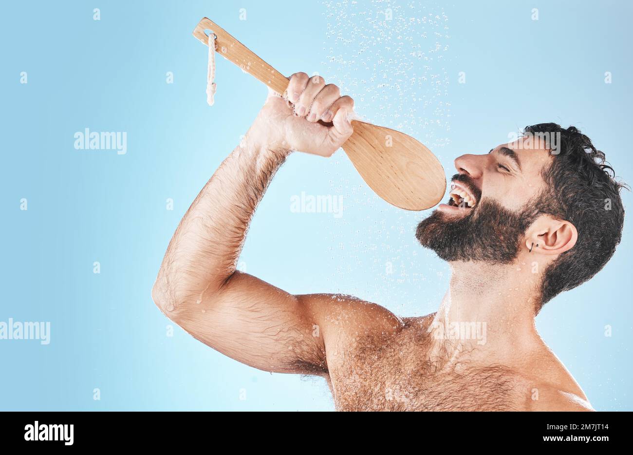 Bathroom, singing and washing with a man model in studio on a blue ...