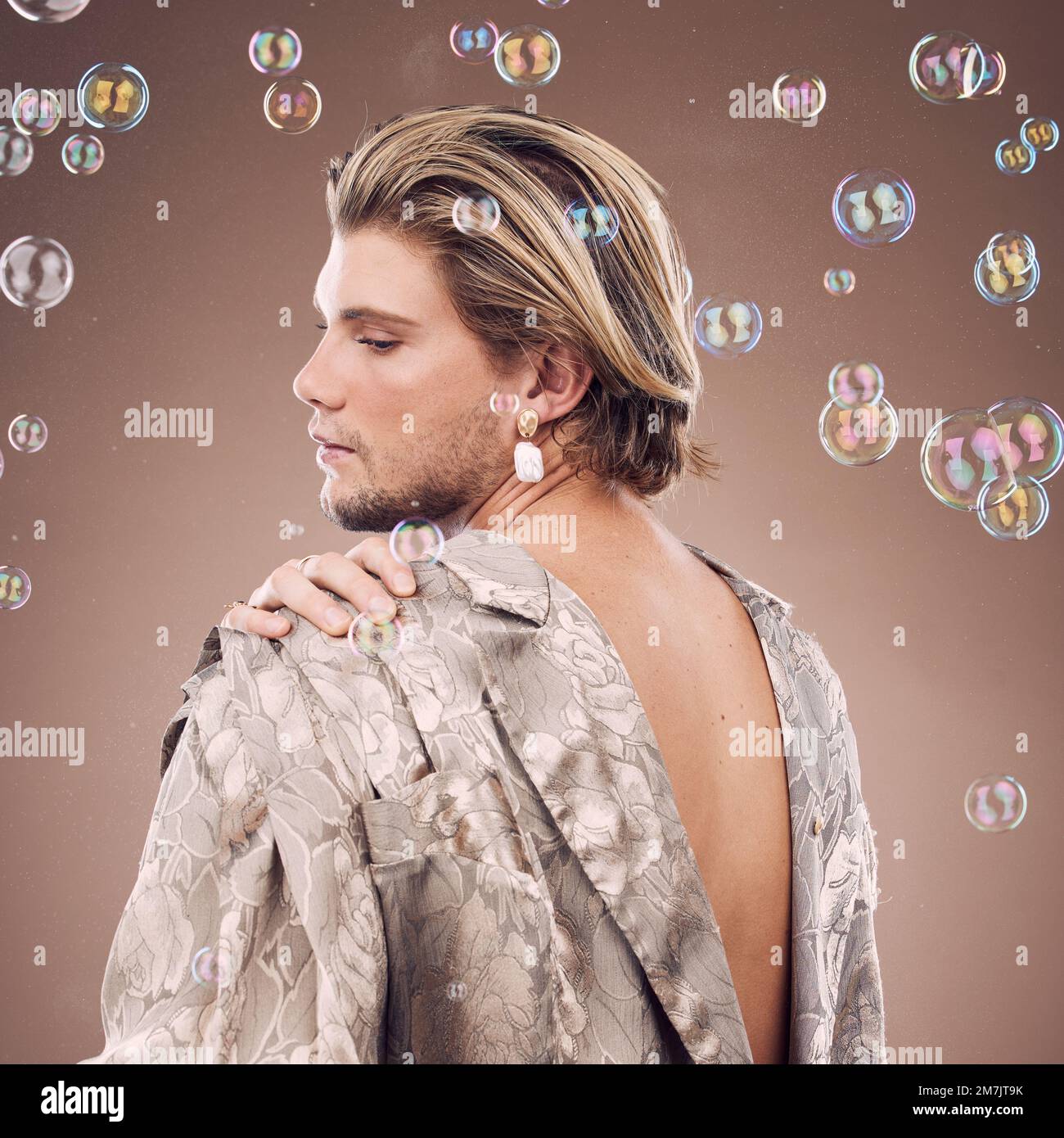 Beauty, lgbtq fashion and man with bubbles in studio on brown ...