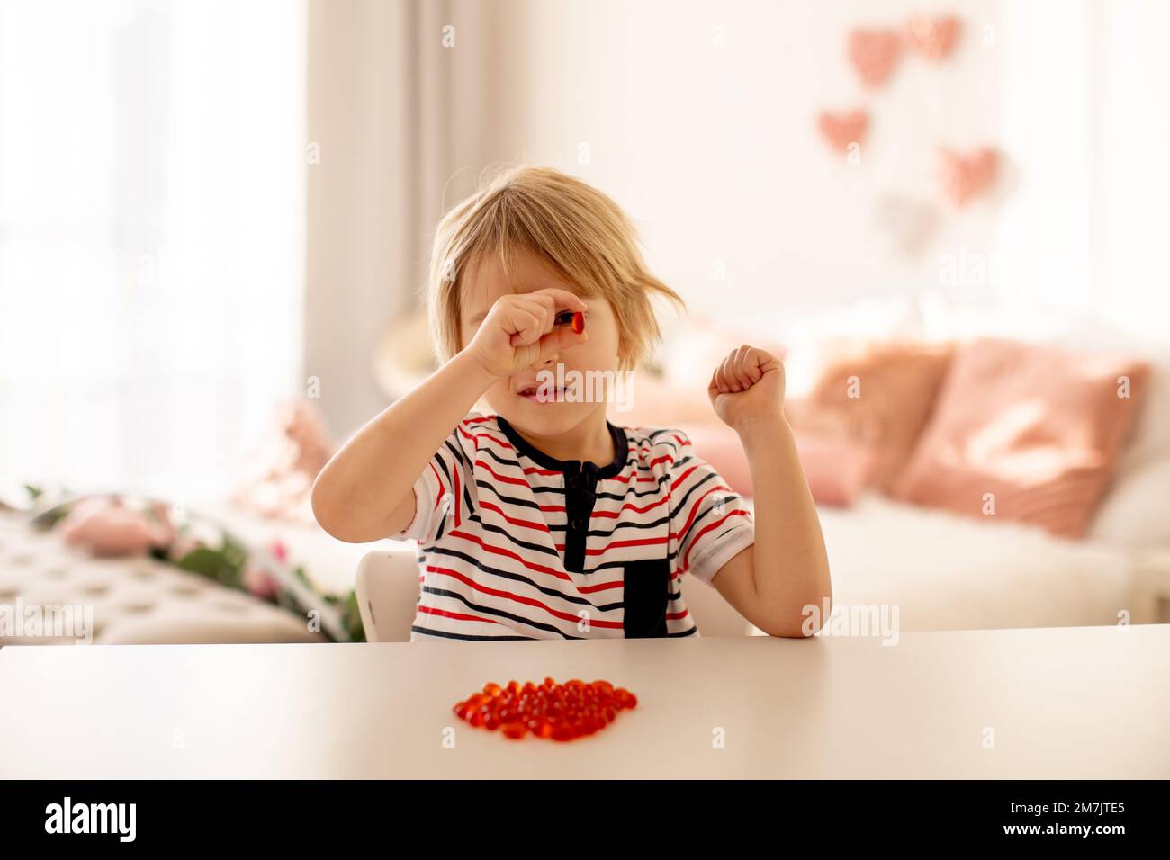 Cute little child, toddler boy, eating alfa omega 3 child suplement ...