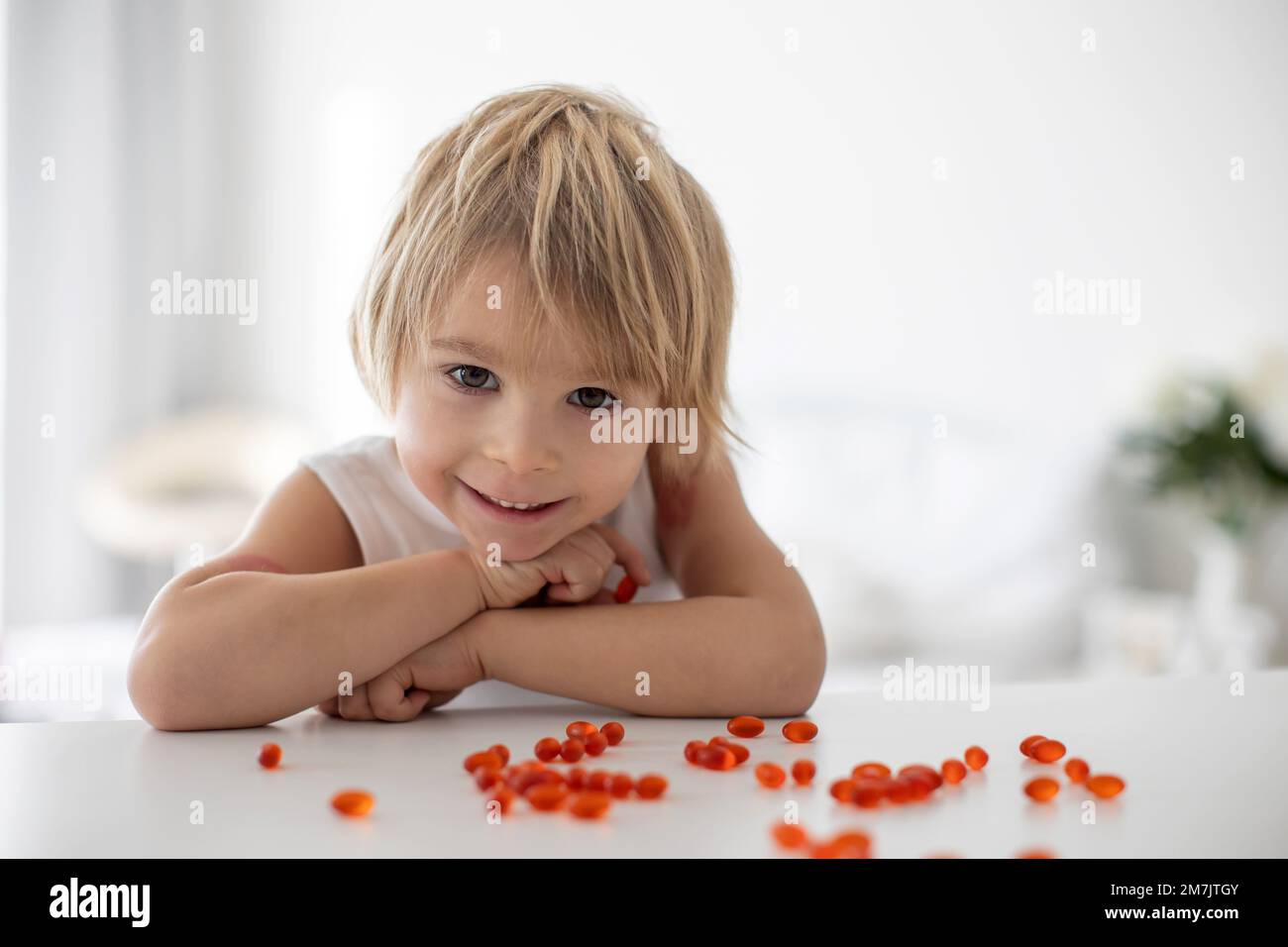 Cute little child, toddler boy, eating alfa omega 3 child suplement ...