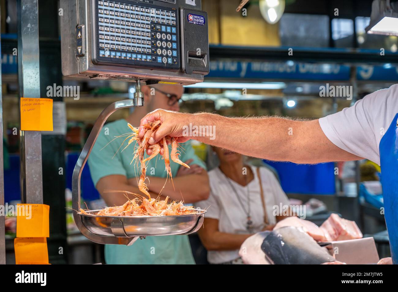 Man weighing out prawns at local food market in Jerez de la Frontera ...