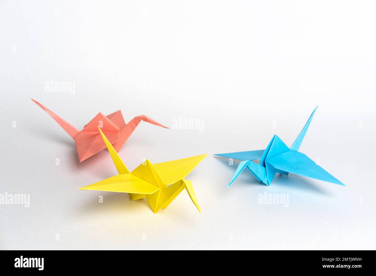 Traditional Japanese origami cranes made of paper on a white background ...