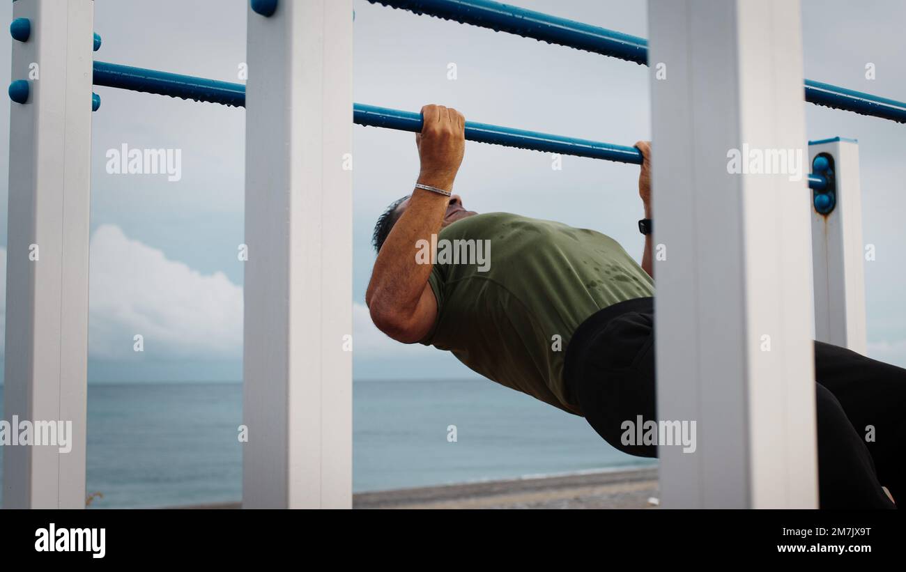 Male doing australian pull-ups on playground Stock Photo - Alamy