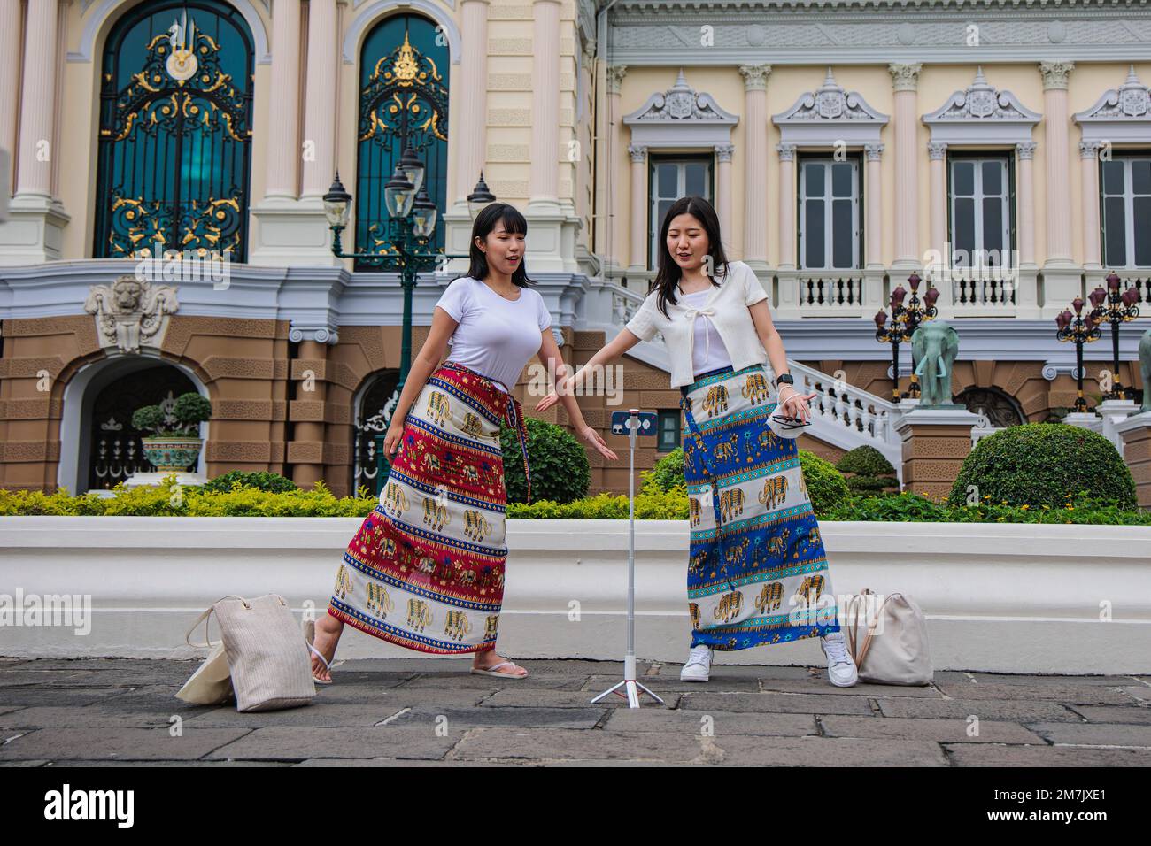 Tourists pose for photos while wearing elephant sarongs at The Grand Palace in Bangkok. The ...