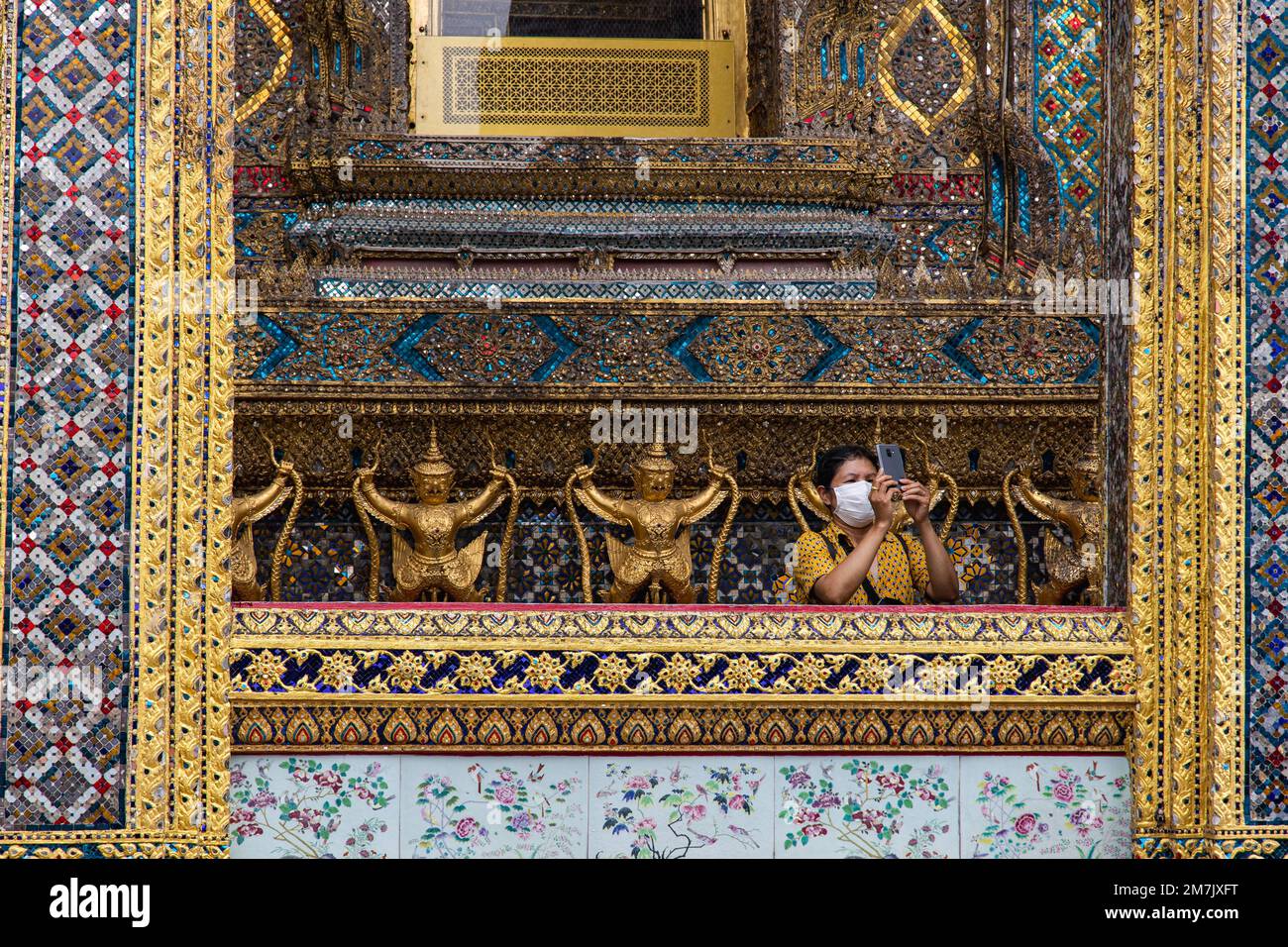 A tourist takes photos inside The Grand Palace in Bangkok. The Grand ...