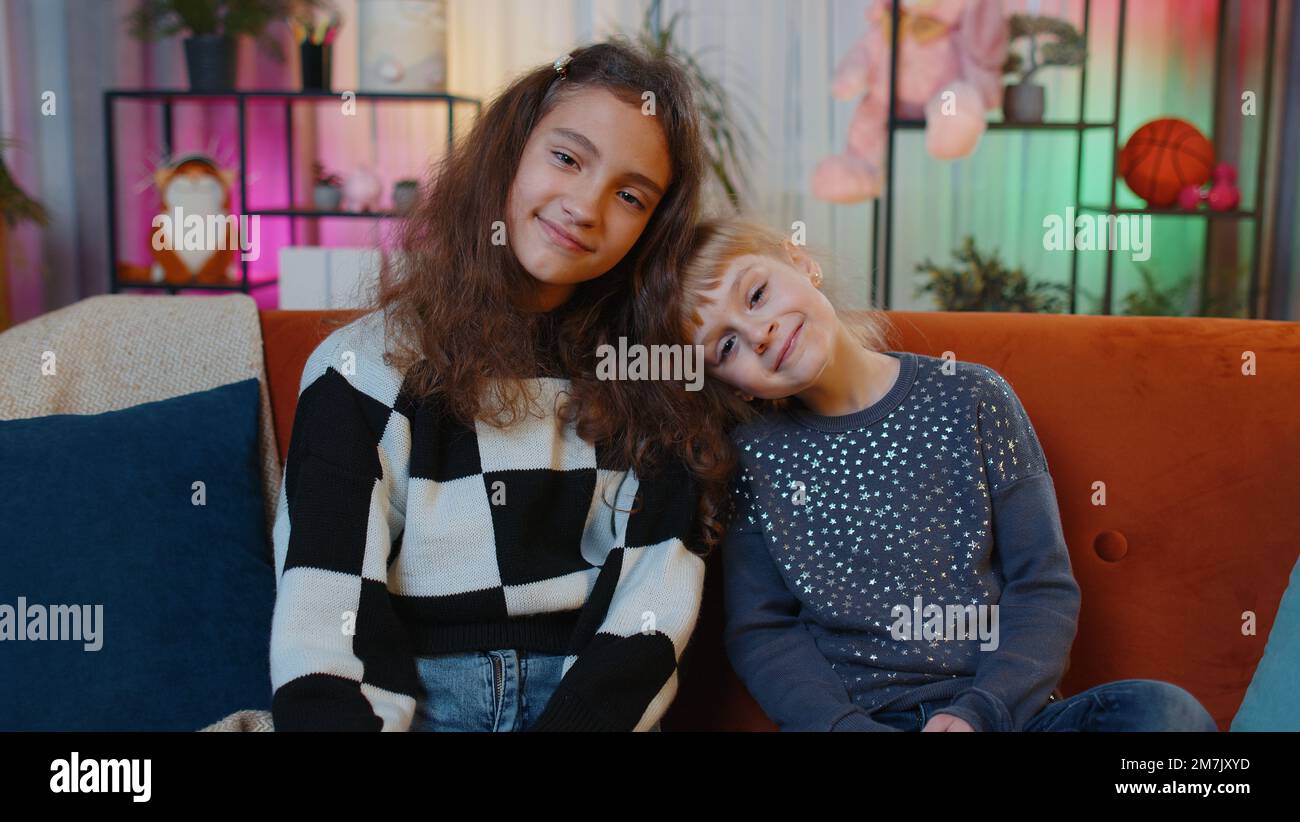 Portrait of happy smiling teenage child and little sister kid looking ...