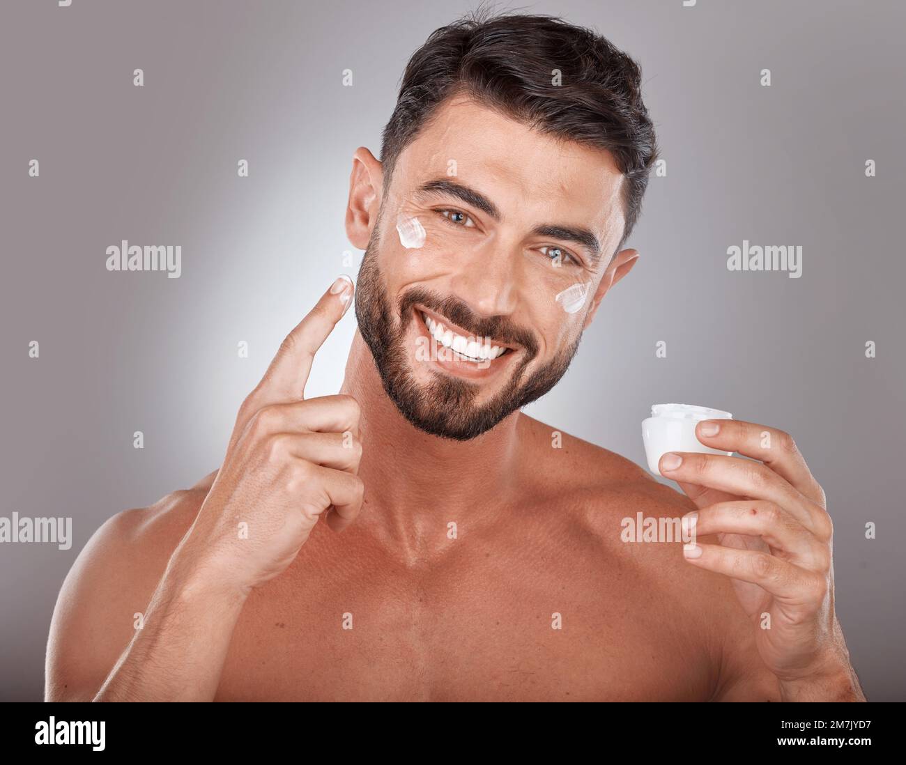 Man, skincare and cream in studio portrait with smile, happiness or ...