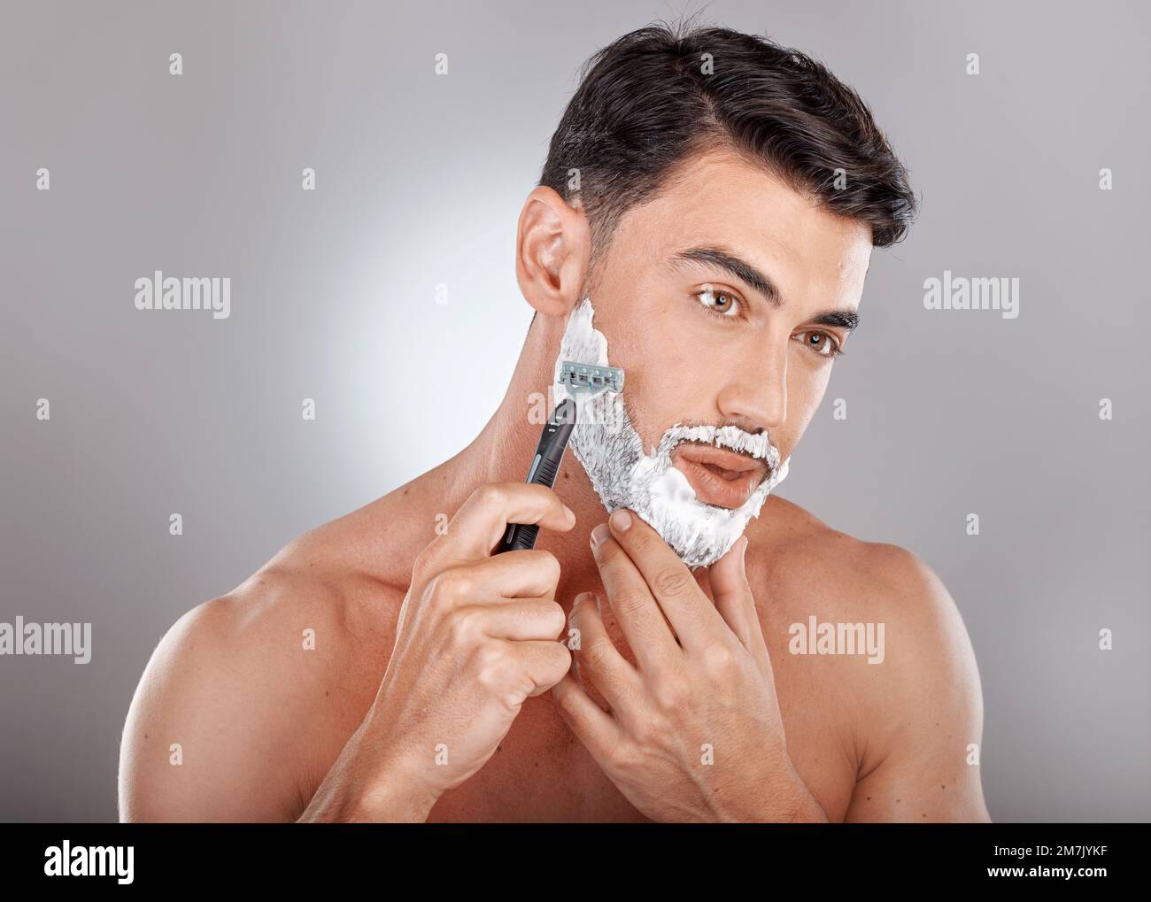 Grooming, foam and shaving with face of man with razor for beauty, hygiene and skincare with ...