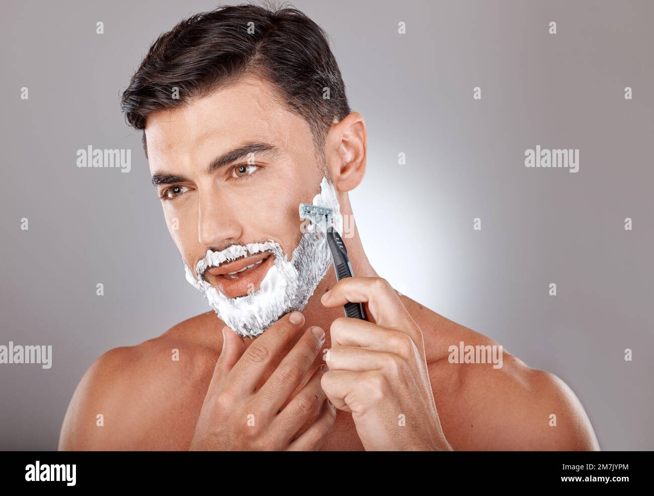 Grooming, foam and shaving with face of man with razor for beauty, hygiene and skincare with ...