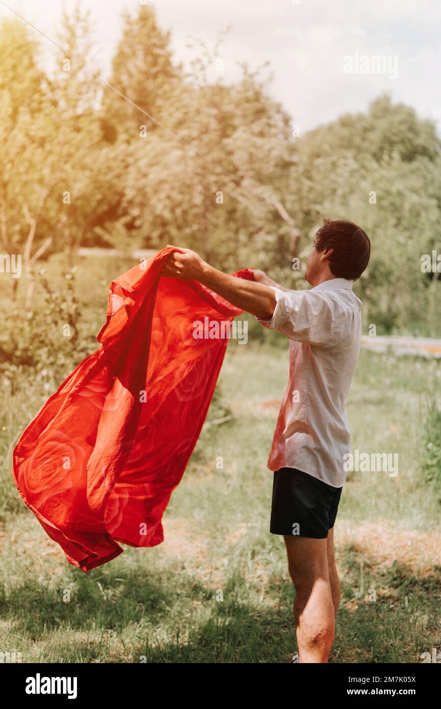 candid young mature choring man chore homework and hanging the laundry ...