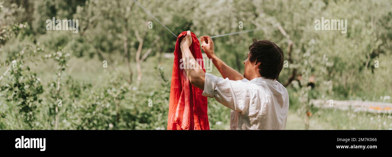 candid young mature choring man chore homework and hanging the laundry ...