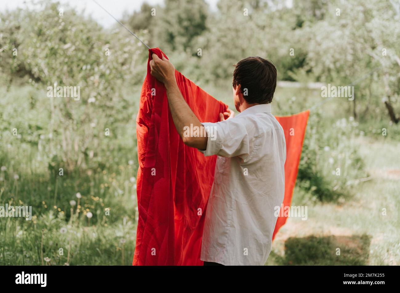 candid young mature choring man chore homework and hanging the laundry ...