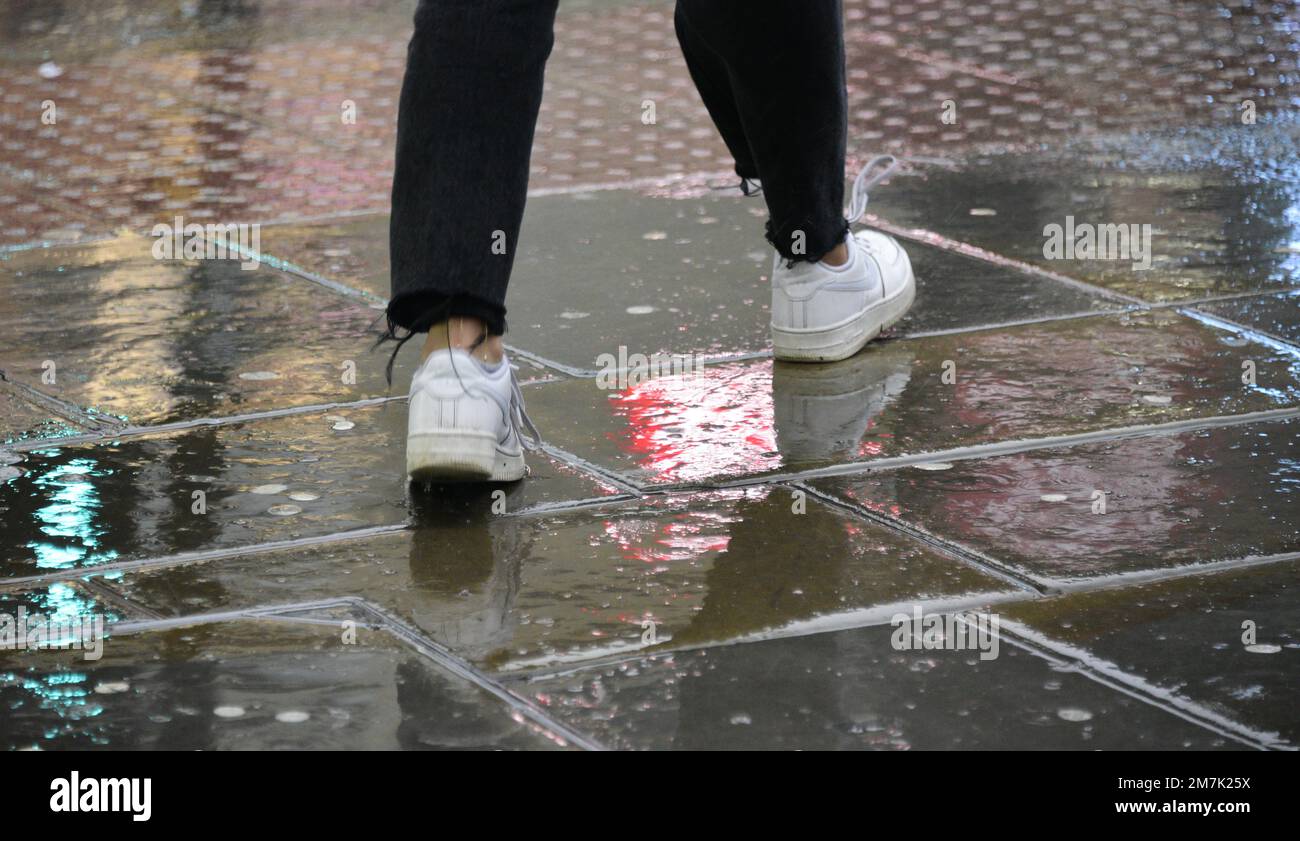 Manchester, UK, 10th January, 2023. Feet on wet pavements. Heavy rain ...