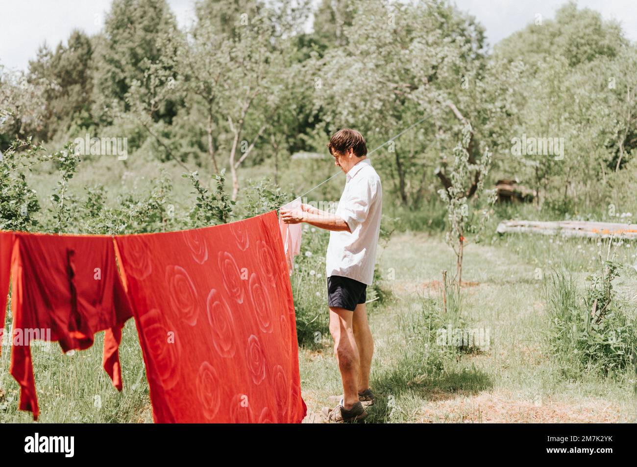candid young mature choring man chore homework and hanging the laundry ...
