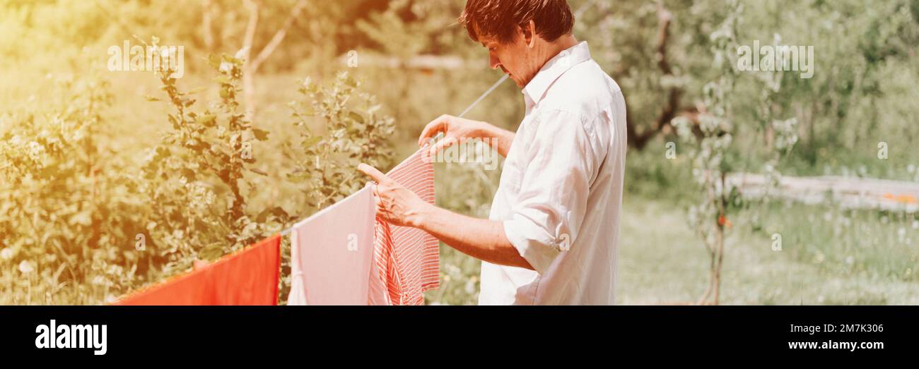 candid young mature choring man chore homework and hanging laundry to ...