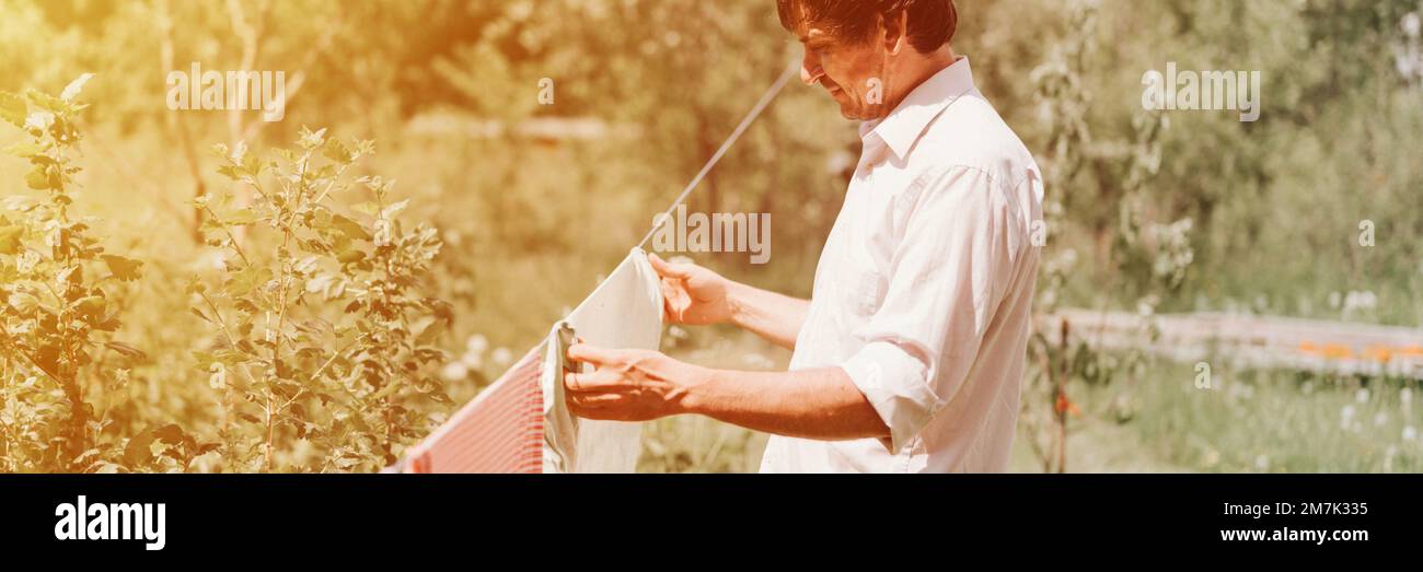 candid young mature choring man chore homework and hanging laundry to ...