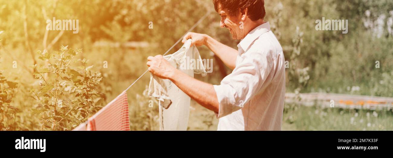 candid young mature choring man chore homework and hanging laundry to ...